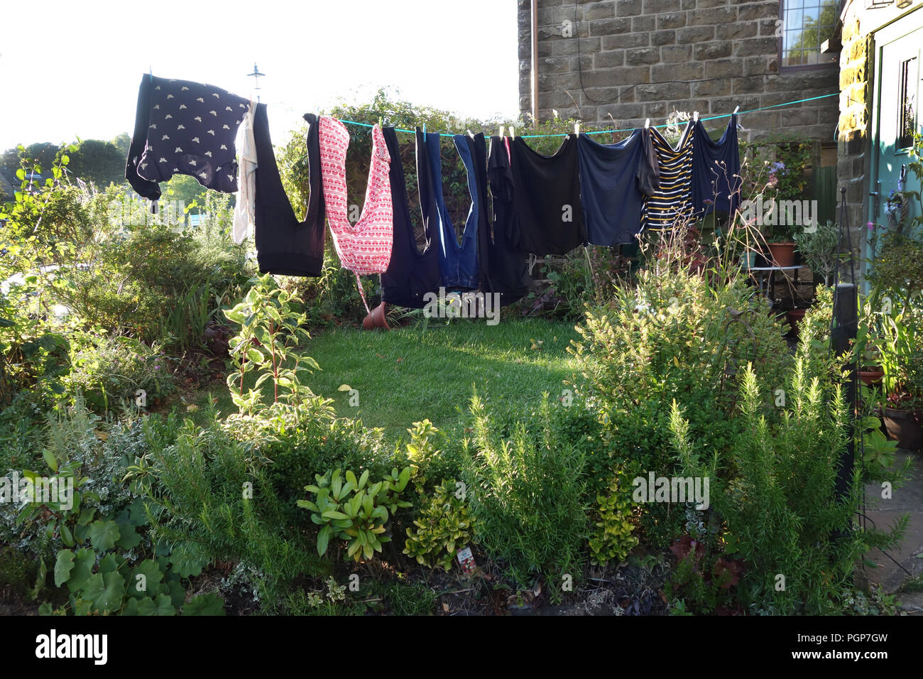 Washing drying on a washing line in a country cottage small front ...