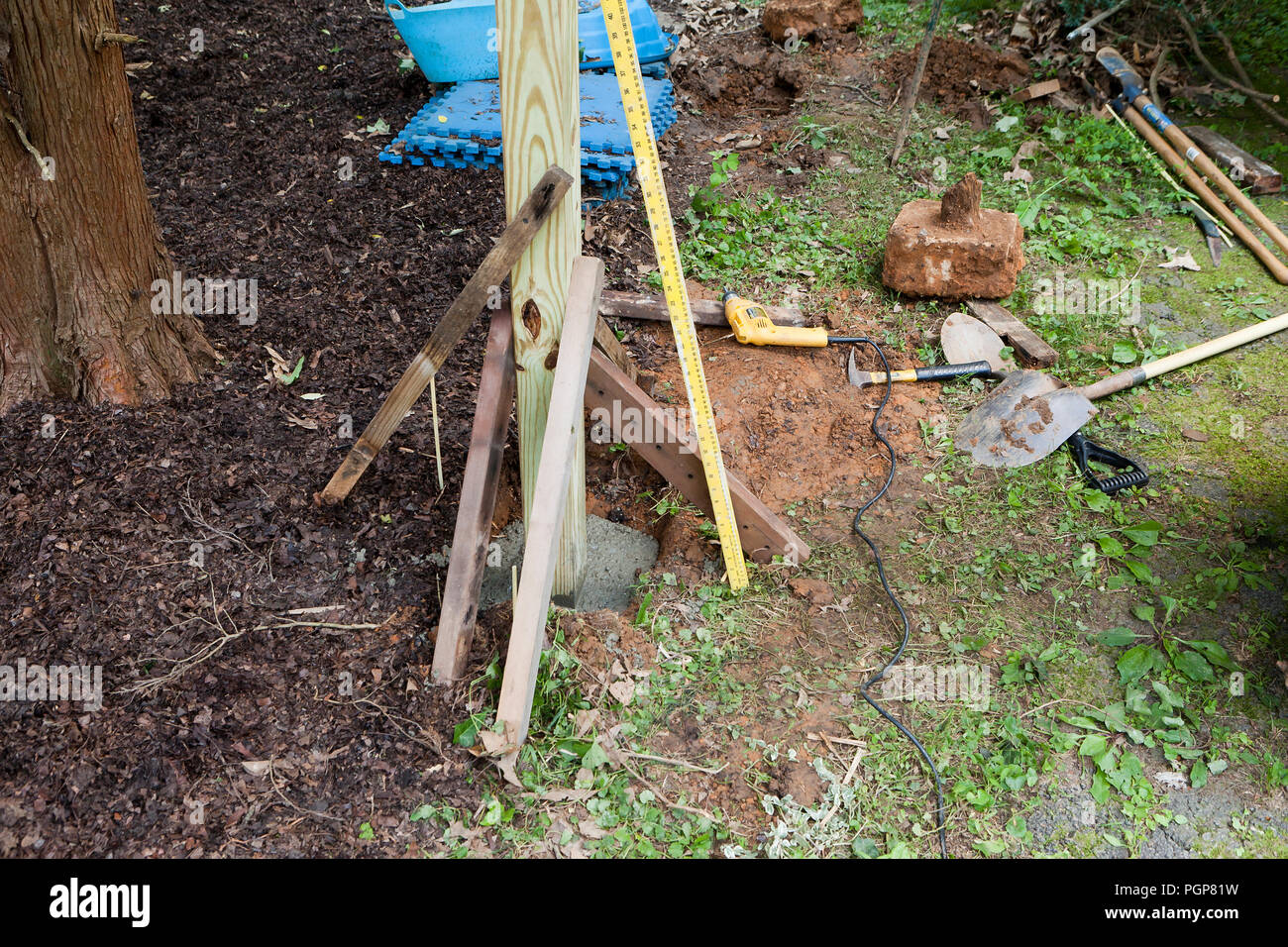 Wood fence post setting in concrete - USA Stock Photo - Alamy