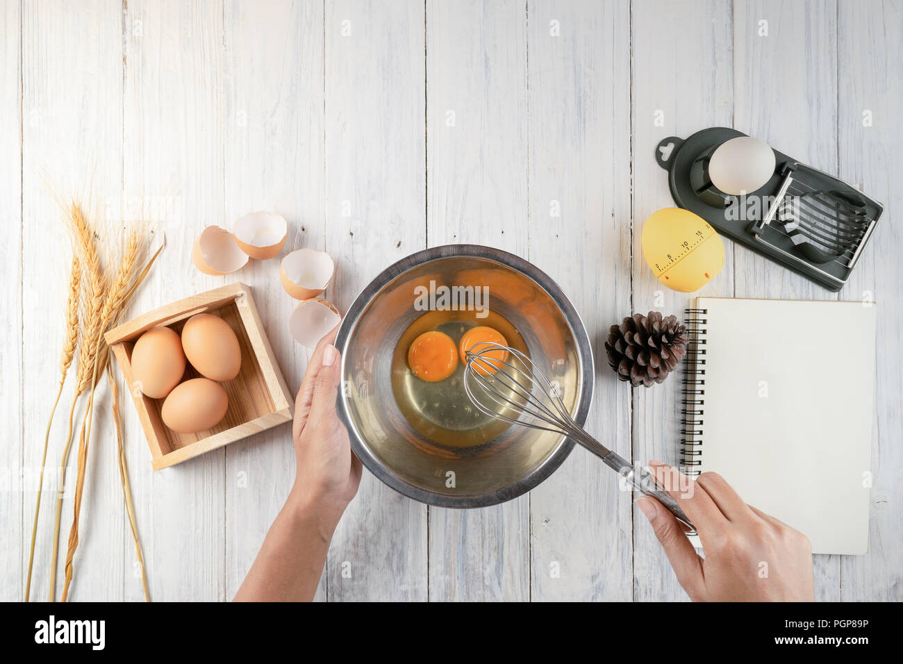 Top view of woman chef breaking an egg into the bowl. Female chef ...