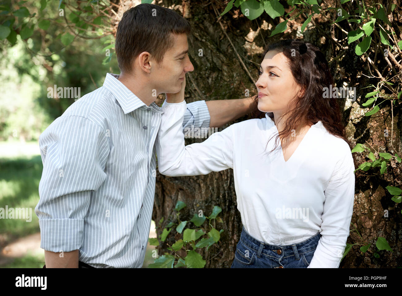 young couple walking in the forest, posing near tree, summer nature ...