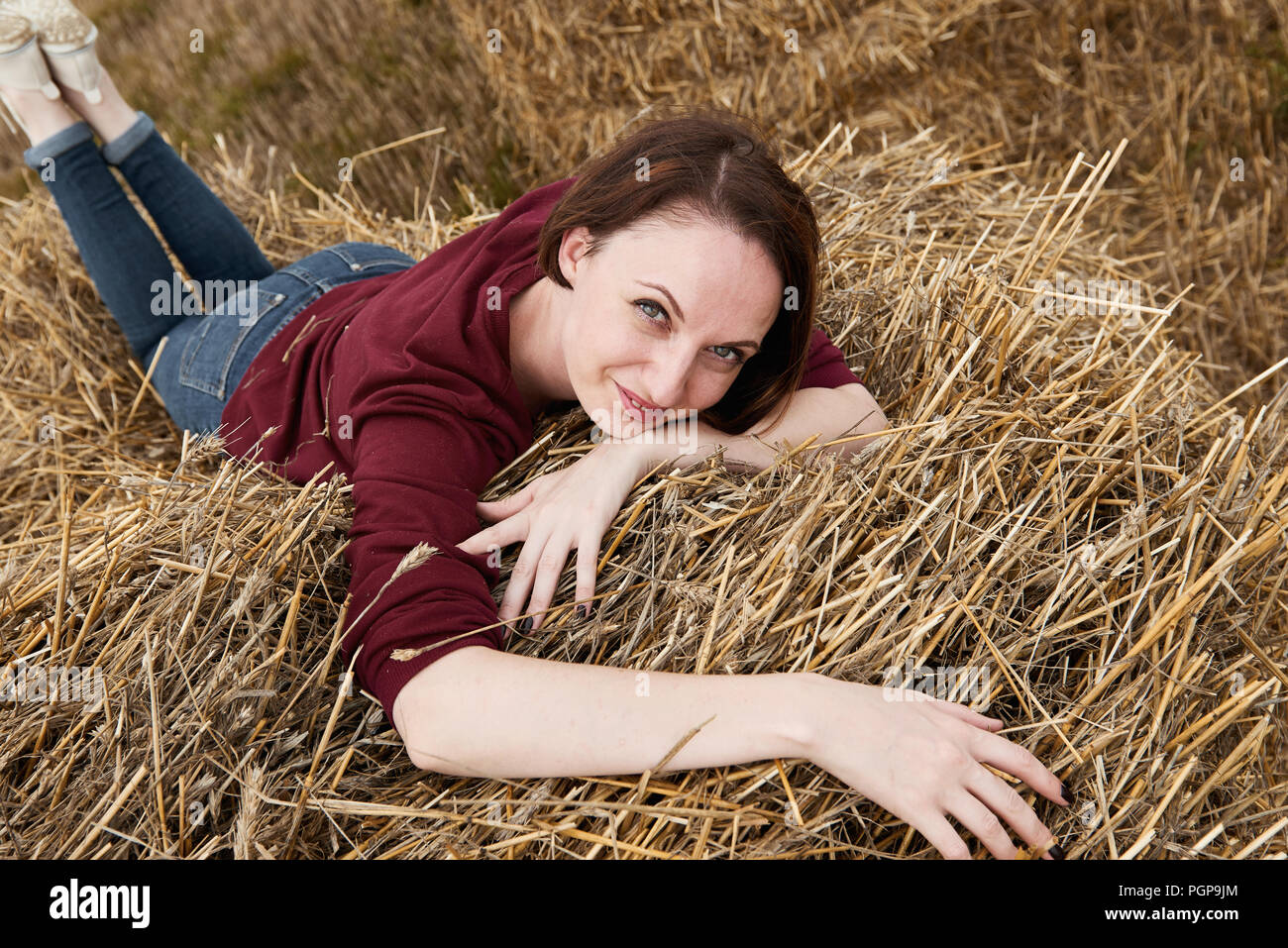 young girl having fun in the field, lying on a haystack Stock Photo - Alamy