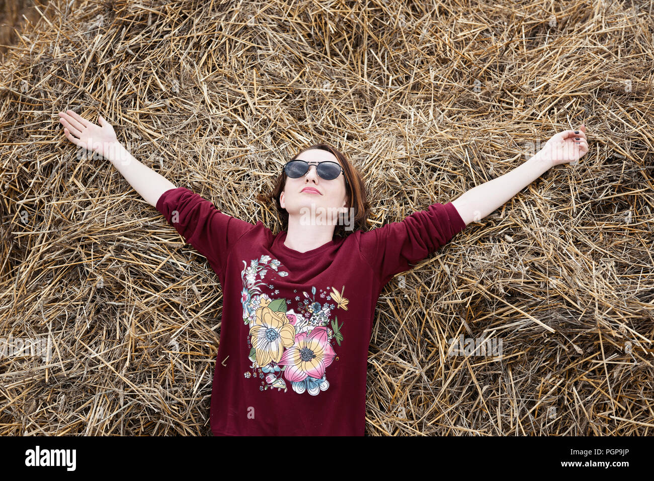 young girl having fun in the field, lying on a haystack Stock Photo - Alamy