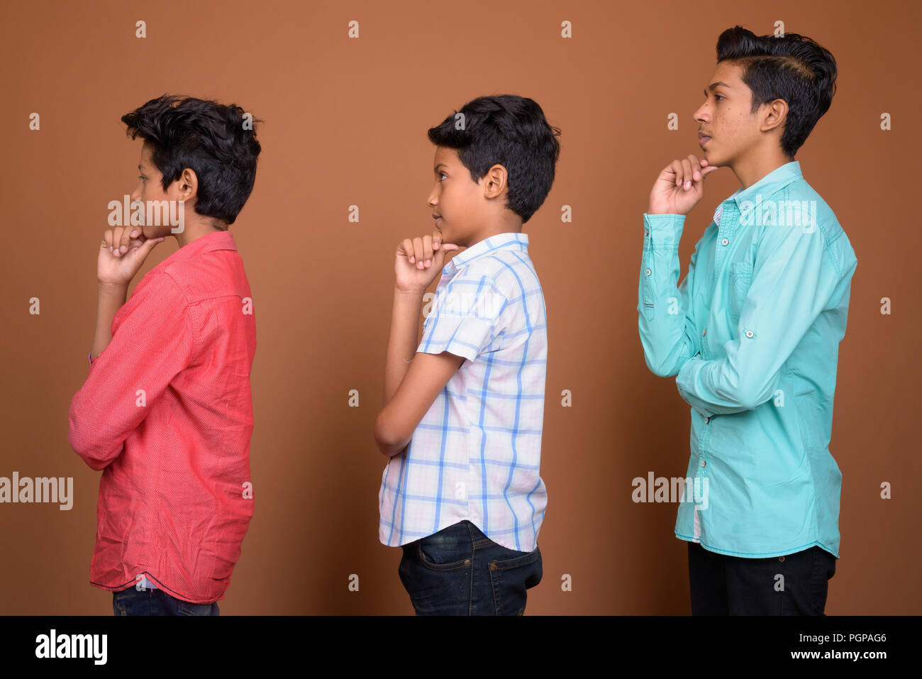 Three young Indian brothers together against brown background Stock ...