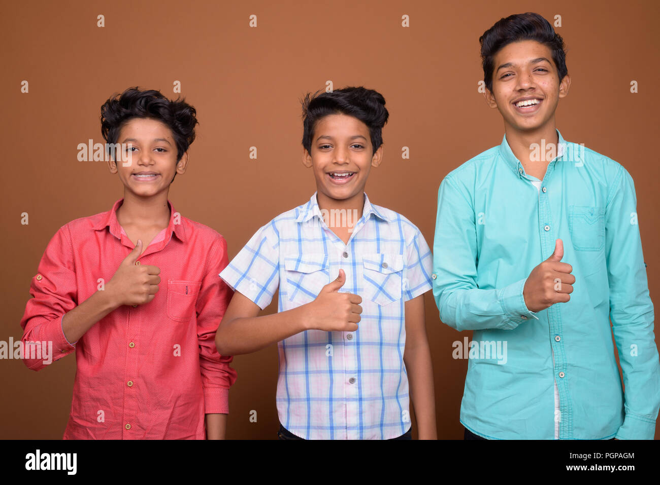 Three young Indian brothers together against brown background Stock ...