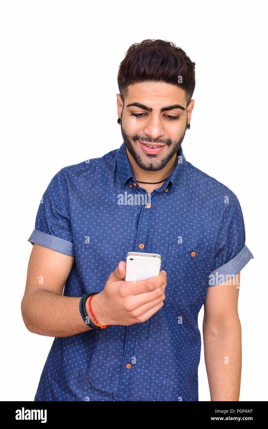 Studio shot of young happy Indian man using mobile phone isolate Stock ...
