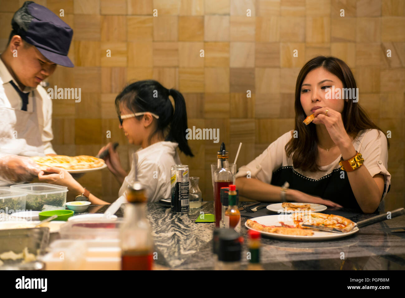 A customer tucks into a slice at Pizza 4Ps flagship store in Ho Chi ...