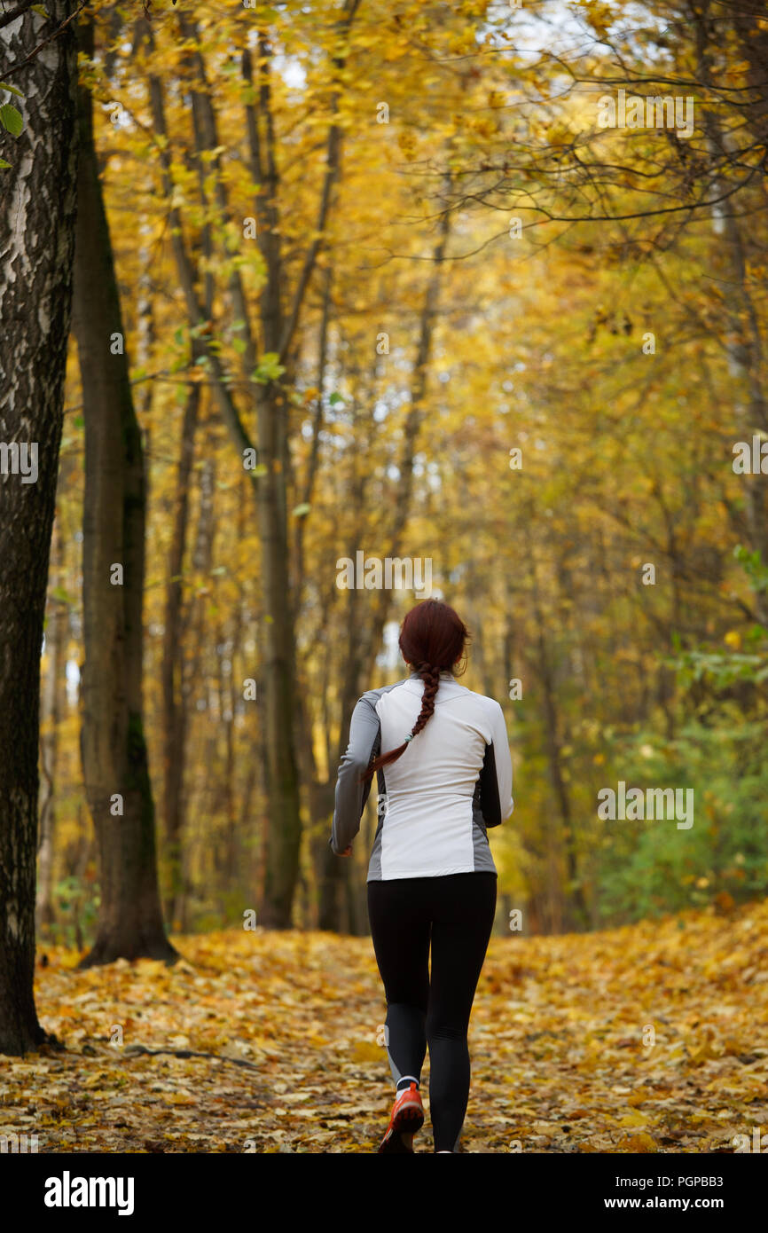 Photo from back in full growth of girl running on autumn foliage Stock ...