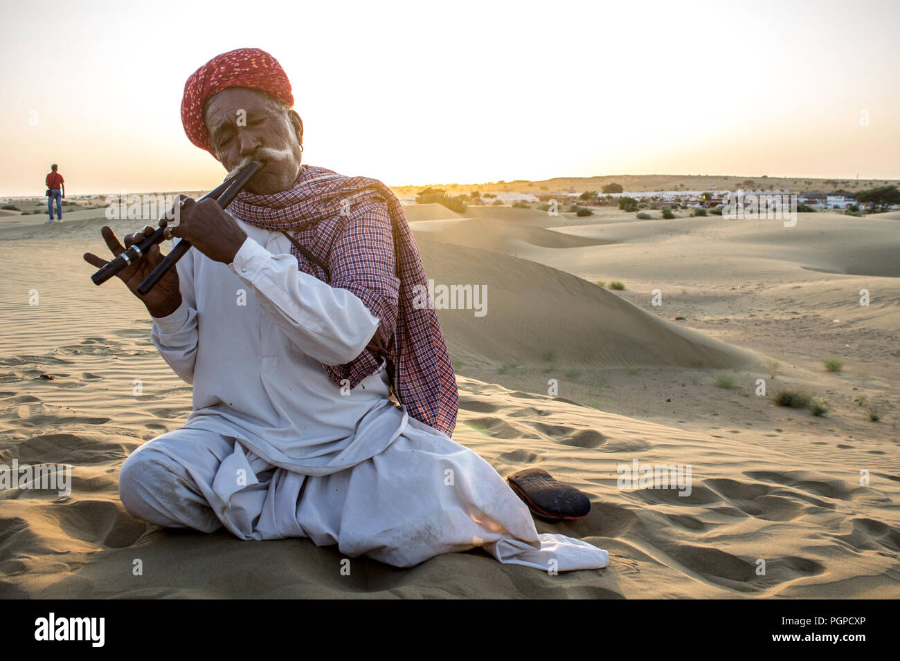 Old man wearing pagari (red turban) playing traditional music in the ...