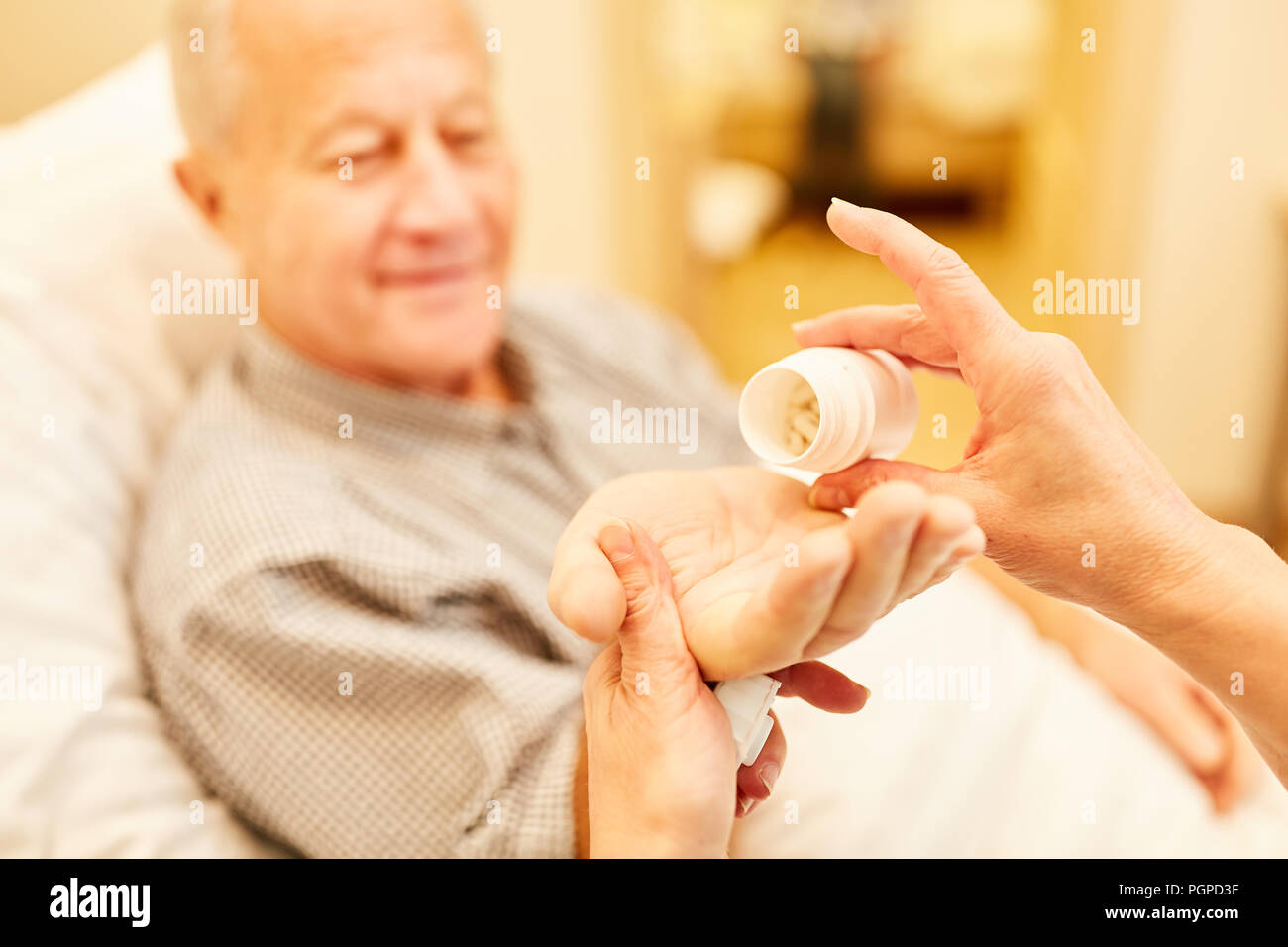 Senior as a patient gets medication from a caregiver in the nursing ...