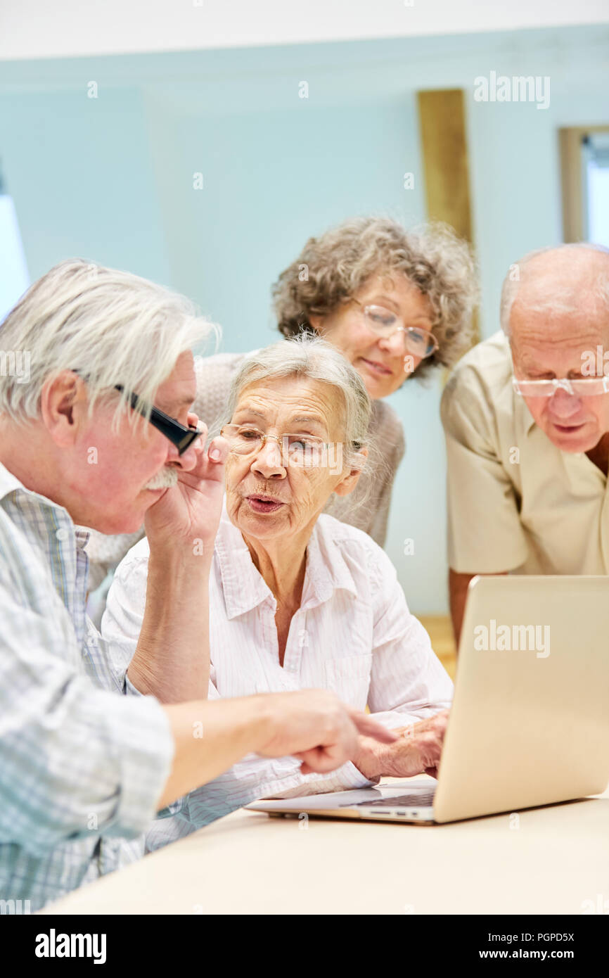 Group of seniors together study at laptop PC in an internet computer ...