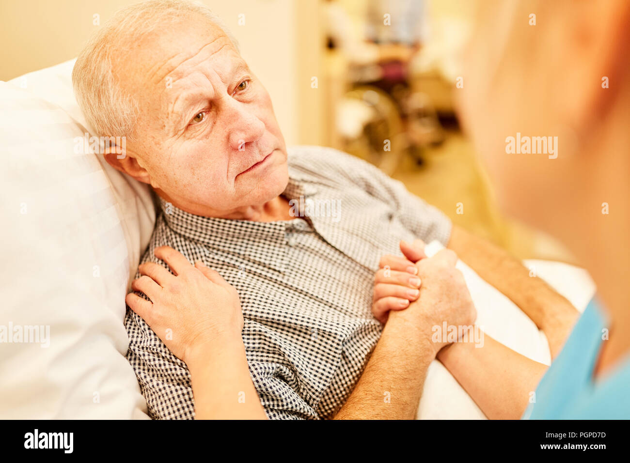 Nursing consoles a sick senior man in a nursing home or in home care ...