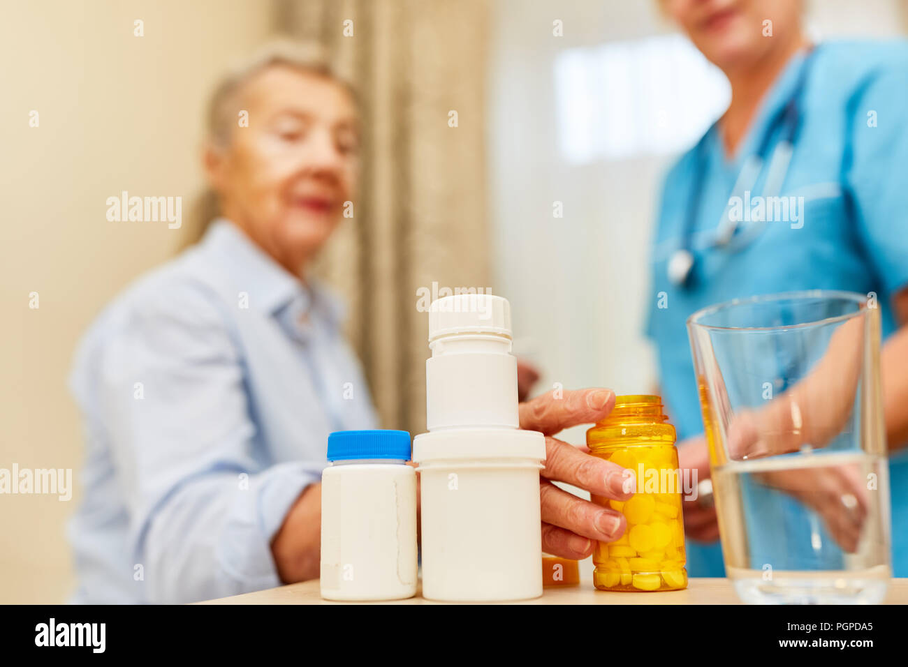 Senior in assisted living with many medications and a nurse Stock Photo ...
