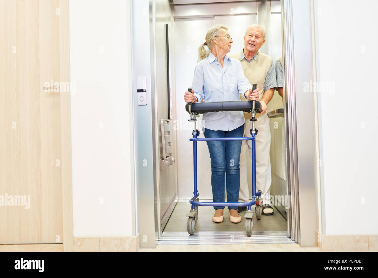 Couple of seniors with rollator in the elevator in a hospital or ...