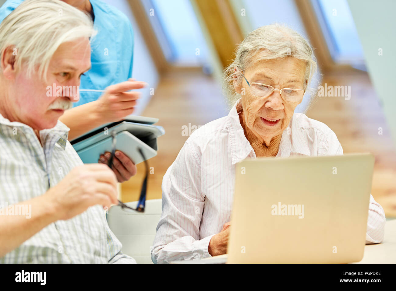 Senior couple in computer course is learning together concentrated with ...