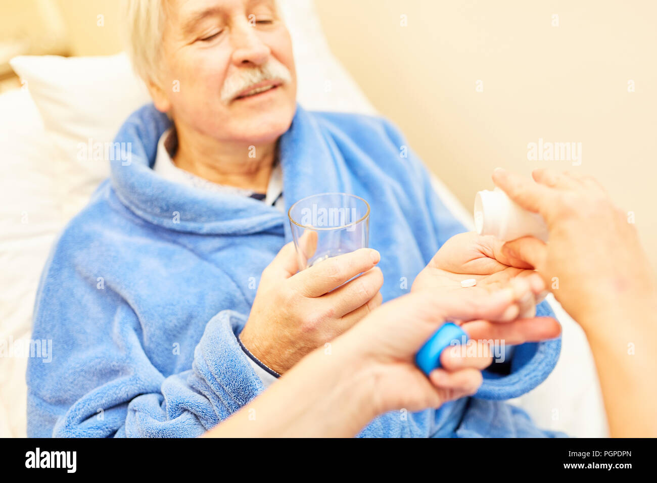 Nursing distributes tablets to a sick senior patient in the nursing ...