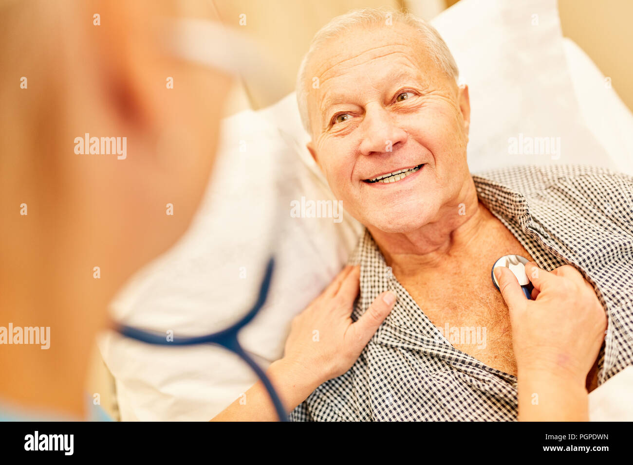 Senior man is listening to the stethoscope while visiting a doctor ...