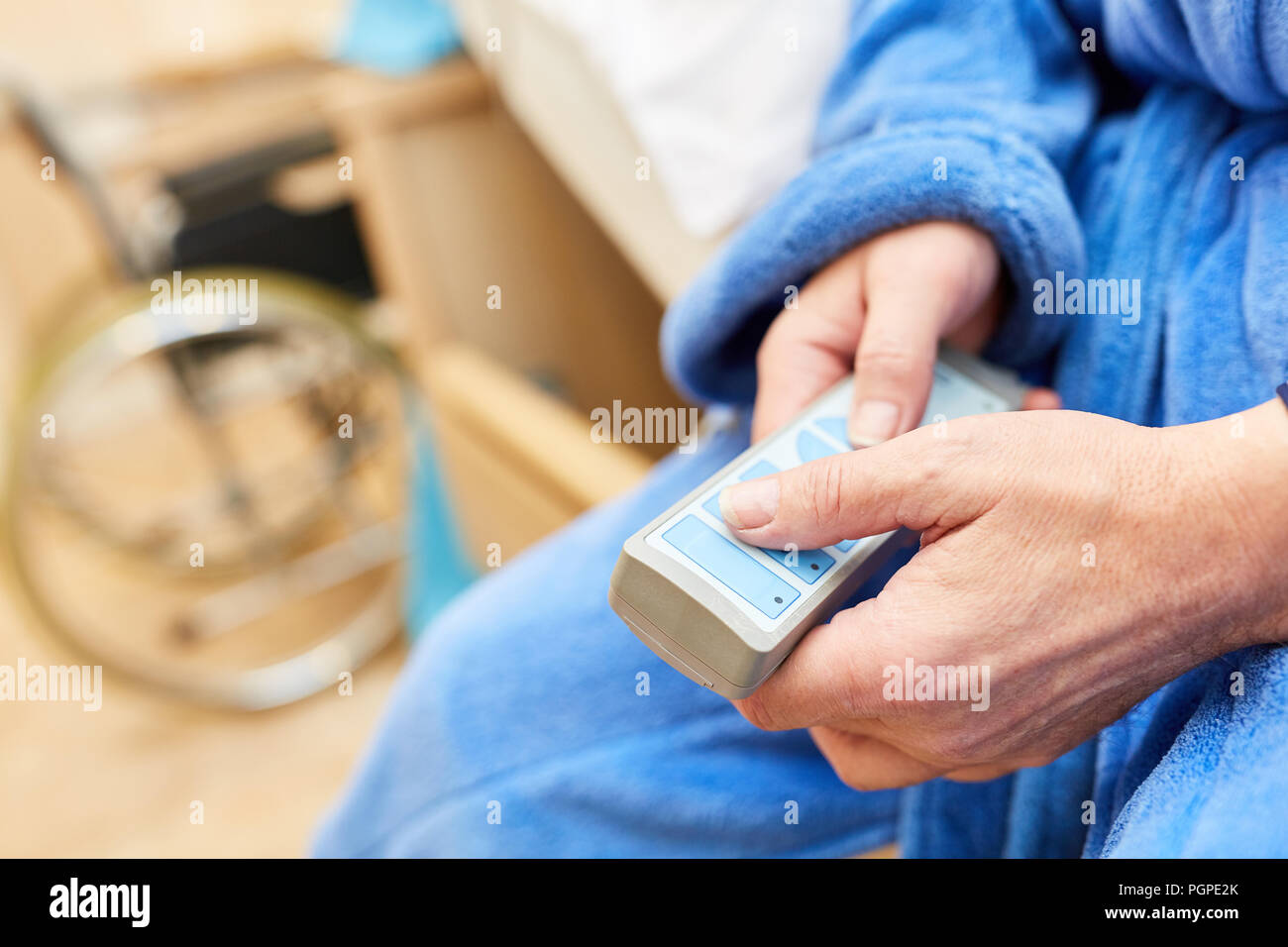 Hands of a senior citizen holding remote control of the nursing bed at ...