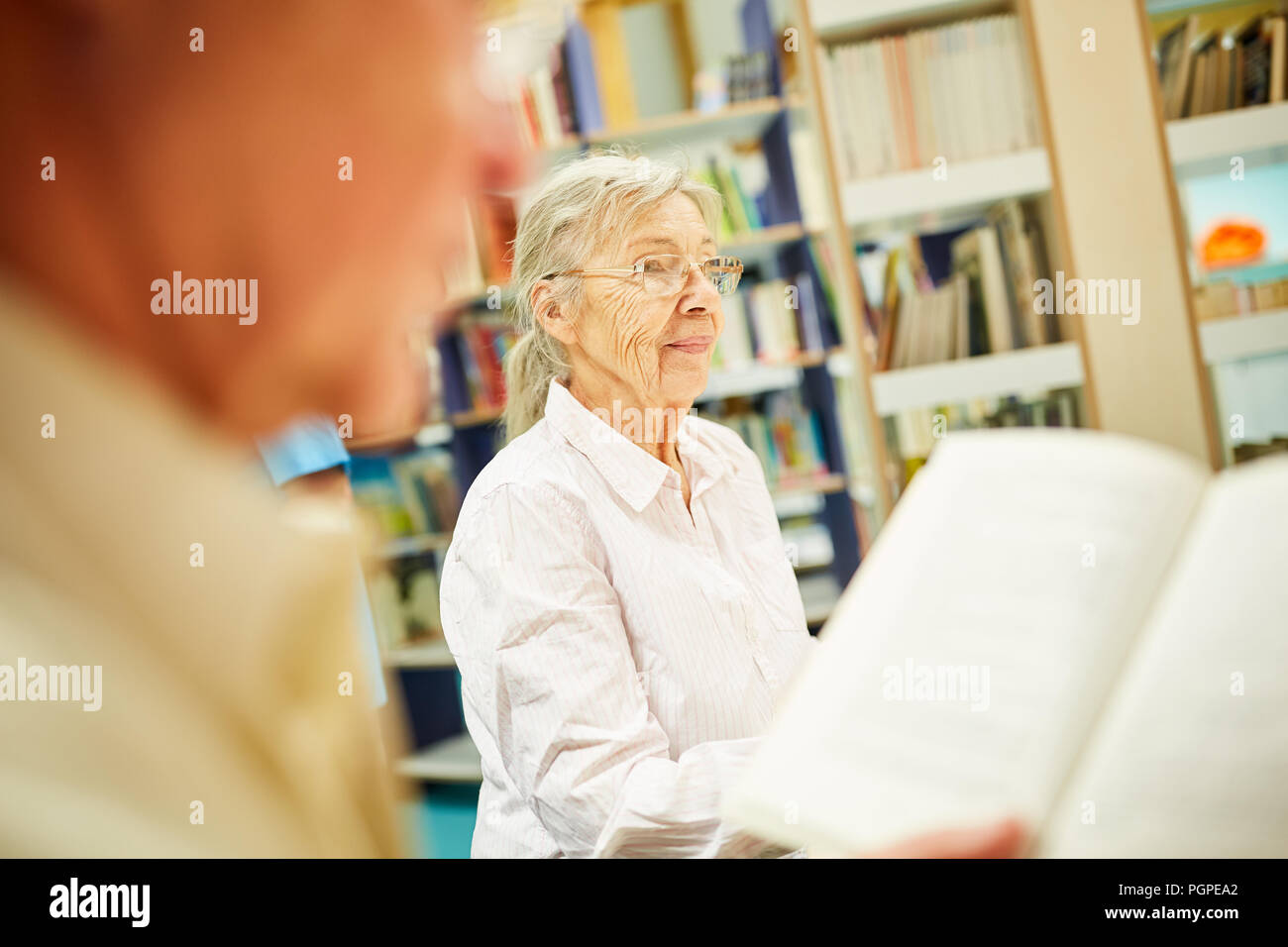 Seniors in a library in the retirement home read books for further ...