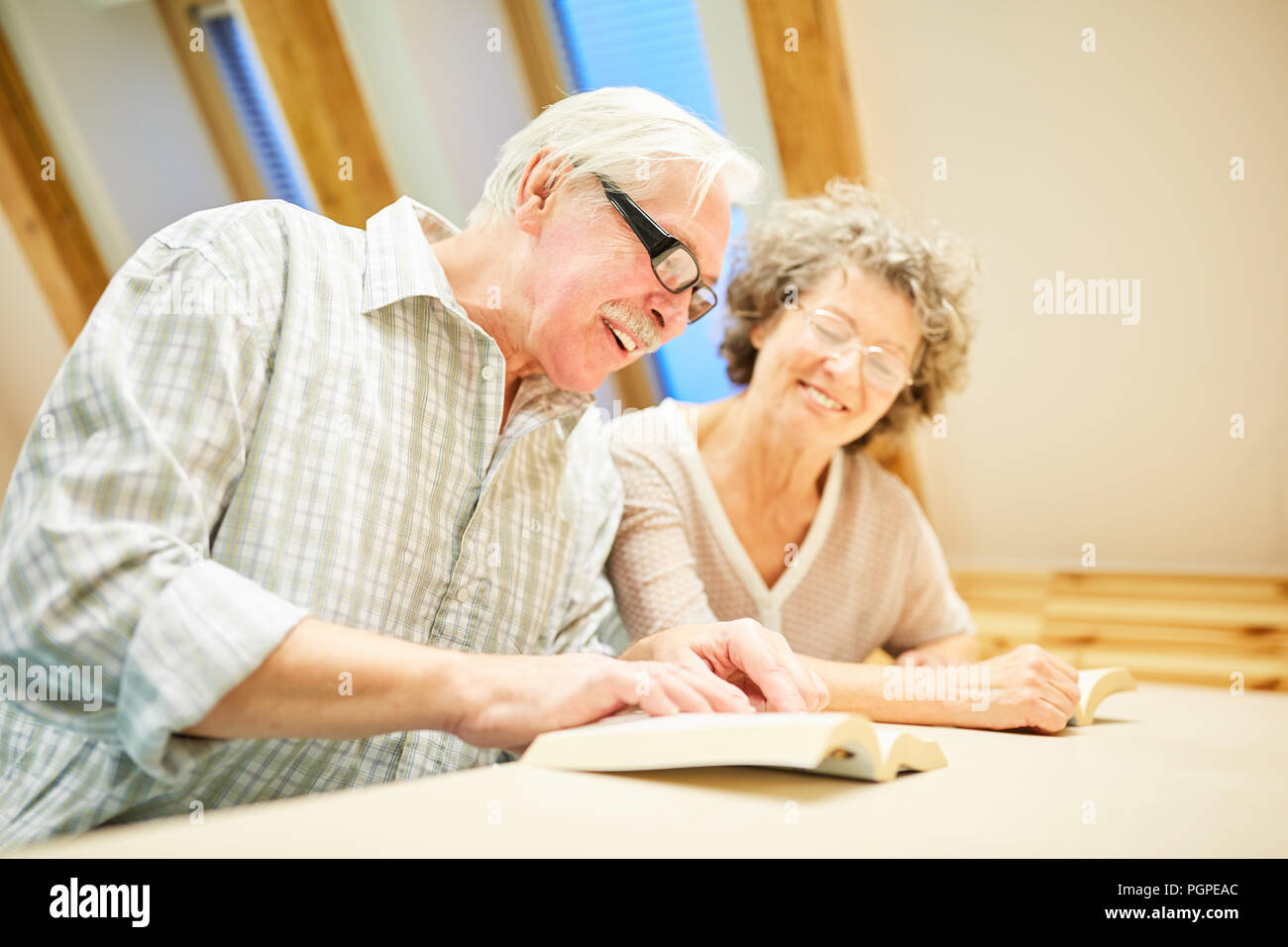 Senior couple with book is having fun reading and studying in reading ...