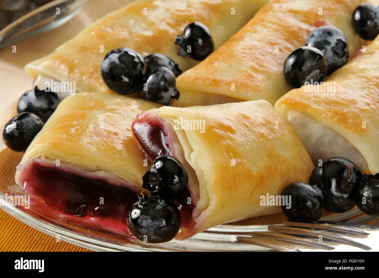 Closeup of golden blueberry blintzes or crepes with fresh berries Stock ...
