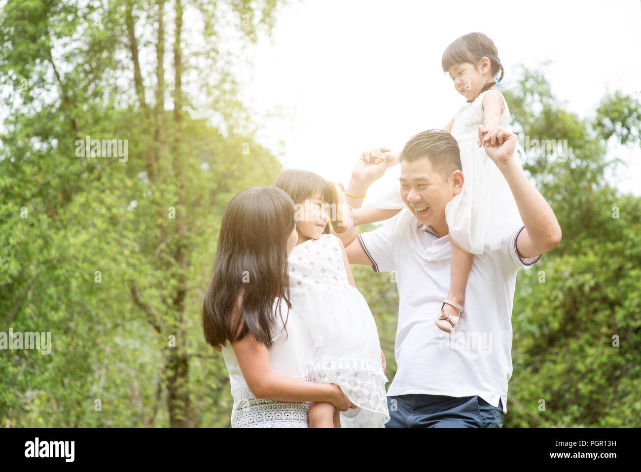 Parents and children having fun at park. Asian family outdoors portrait ...