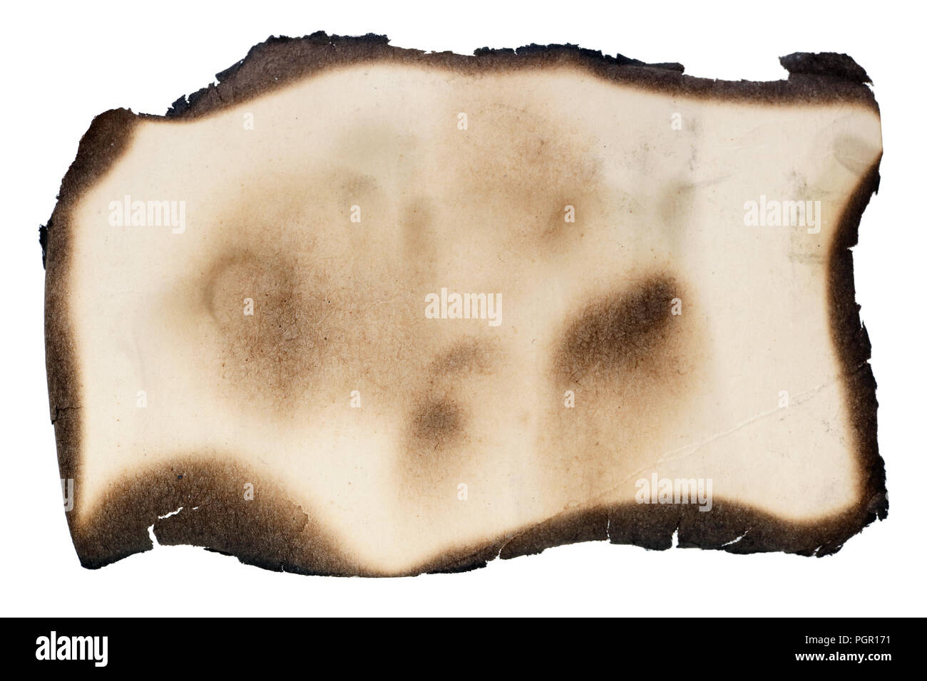 A small piece of yellow aged vintage paper with burned black edges ...