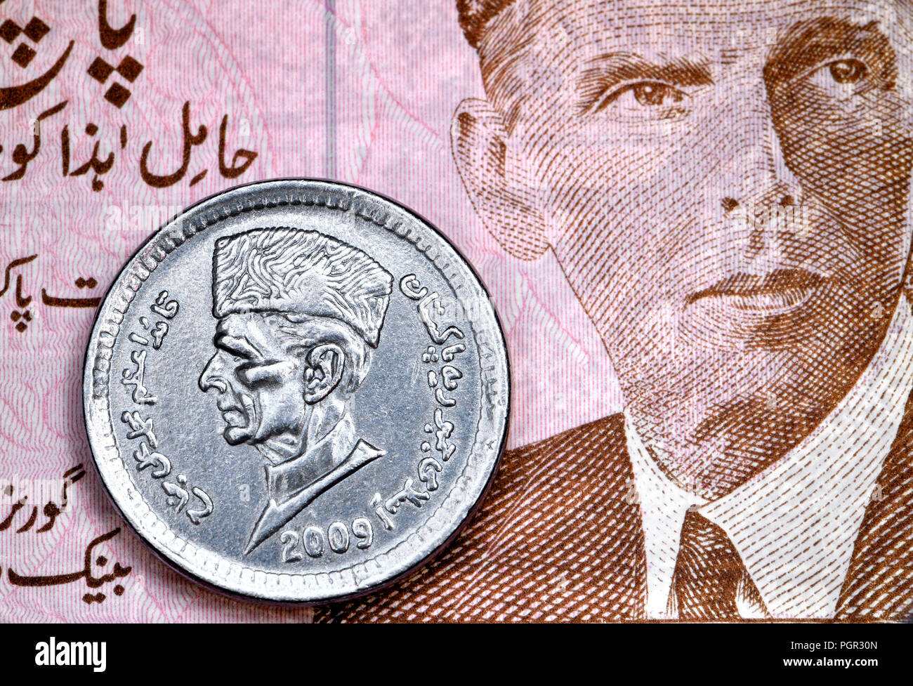 Pakistan 1 Rupee coin (2009) on a 5 Rupee banknote, both showing the ...