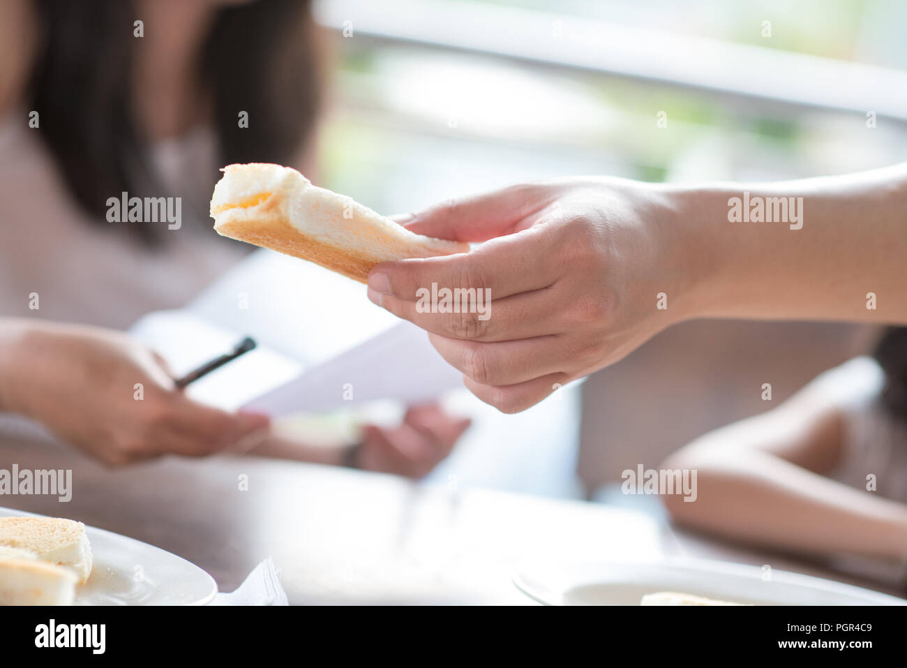 Close up human hand holding toast bread at cafeteria Stock Photo - Alamy