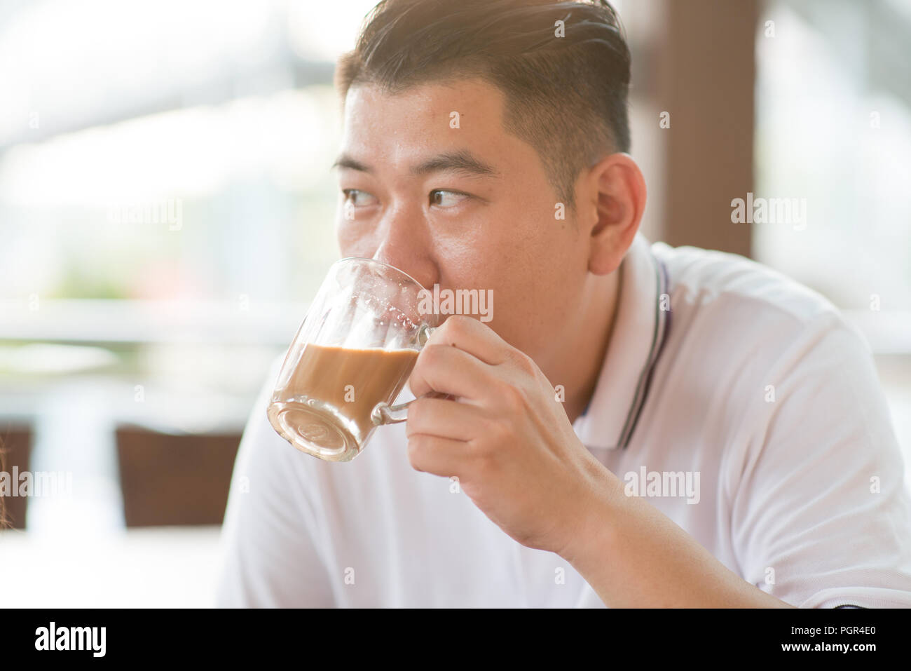 Asian mature man drinking milk tea at cafe. Outdoor lifestyle with ...