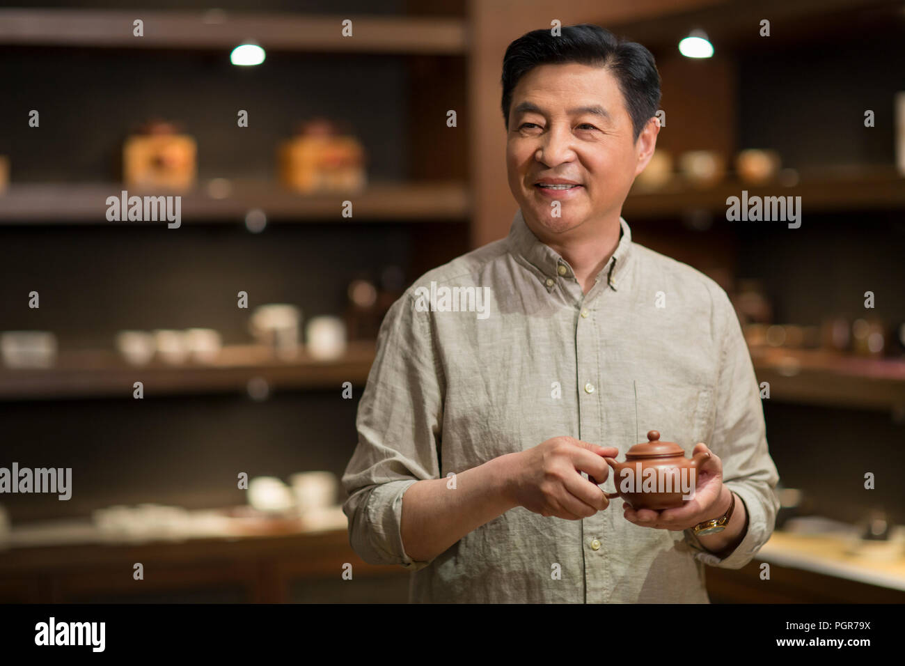 Mature man holding a teapot Stock Photo - Alamy