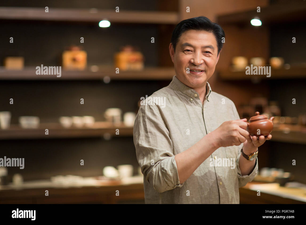 Mature man showing a teapot Stock Photo - Alamy
