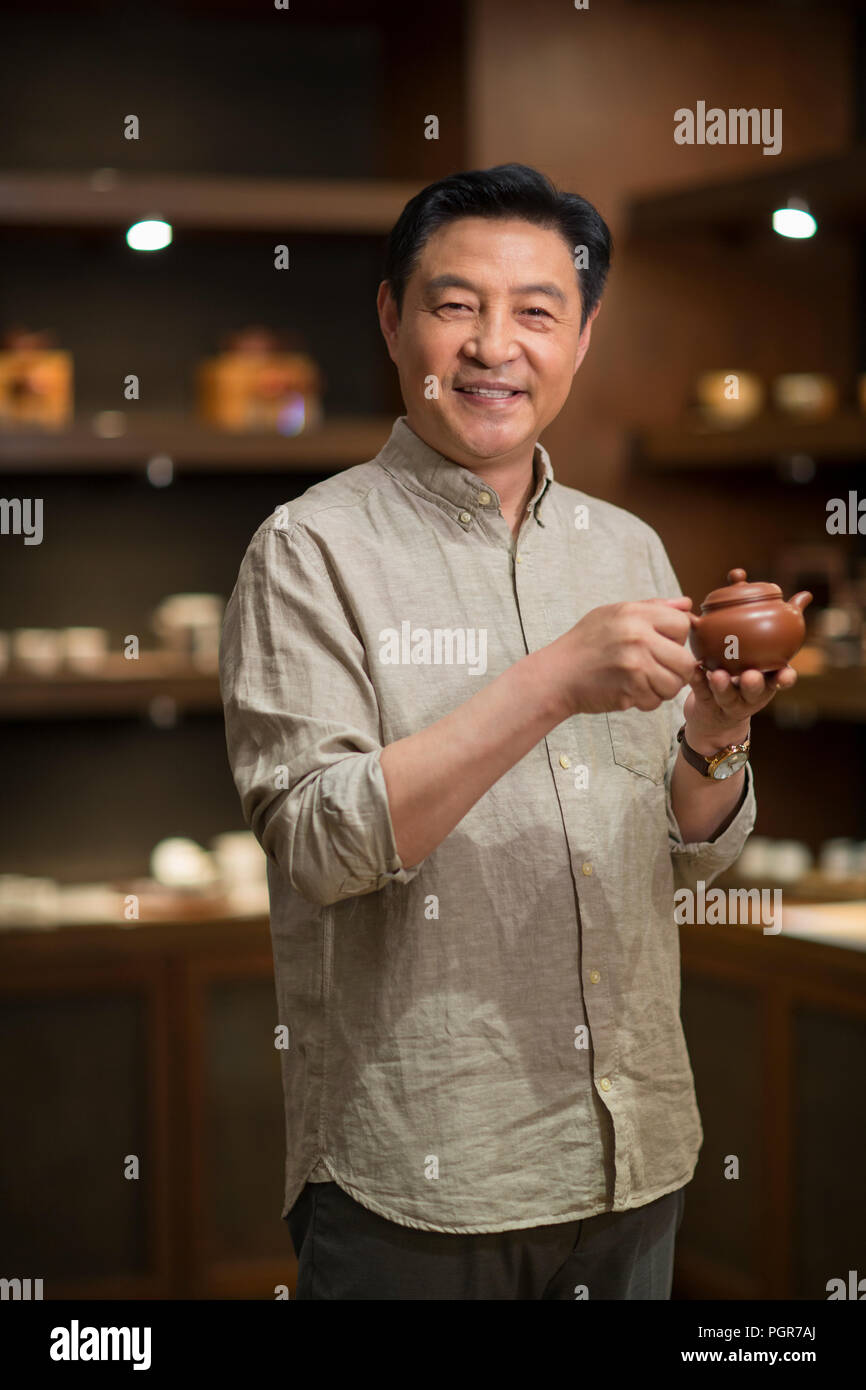Mature man showing a teapot Stock Photo - Alamy