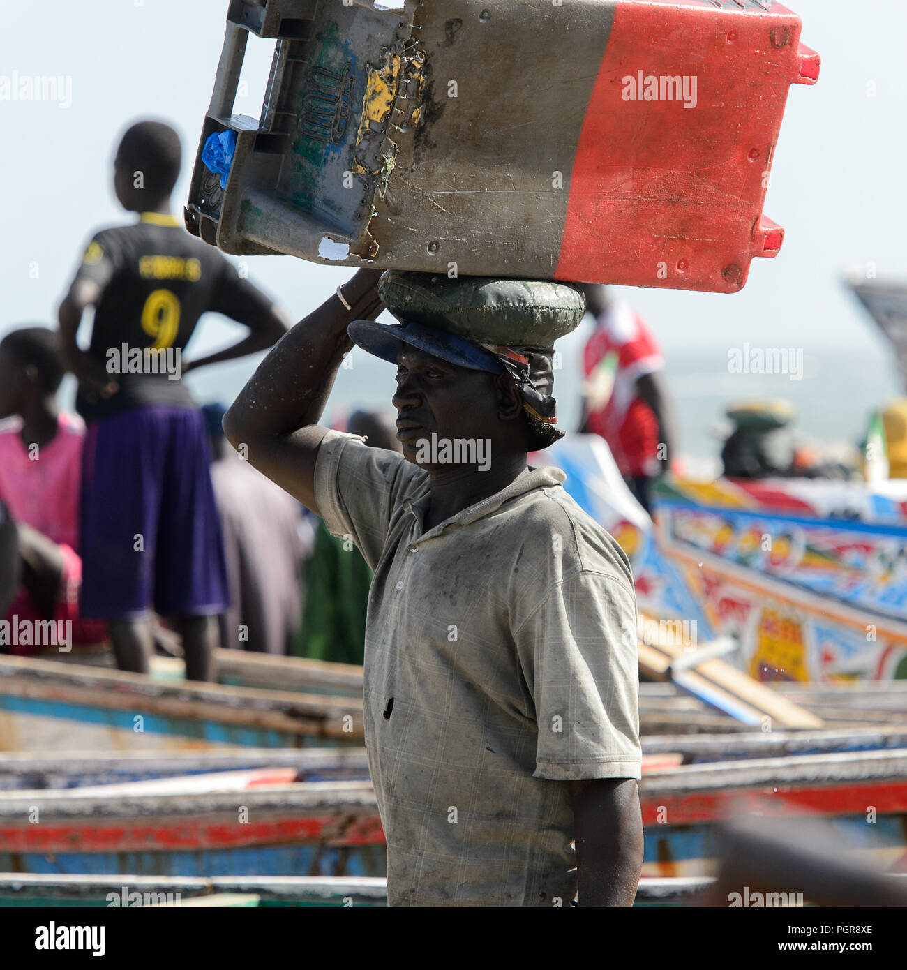KAYAR, SENEGAL - APR 27, 2017: Unidentified Senegalese man carries a ...