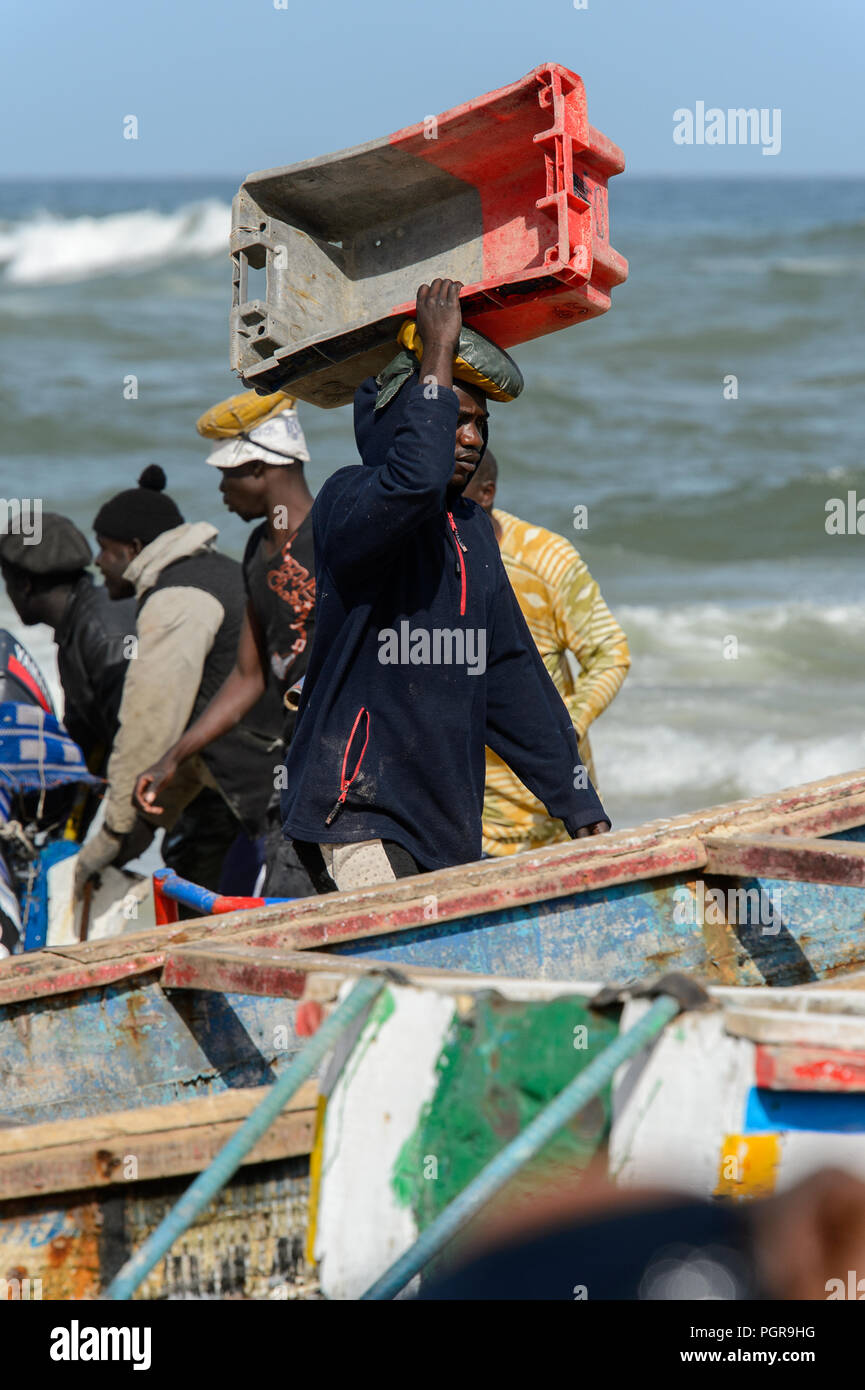 KAYAR, SENEGAL - APR 27, 2017: Unidentified Senegalese man carries a ...