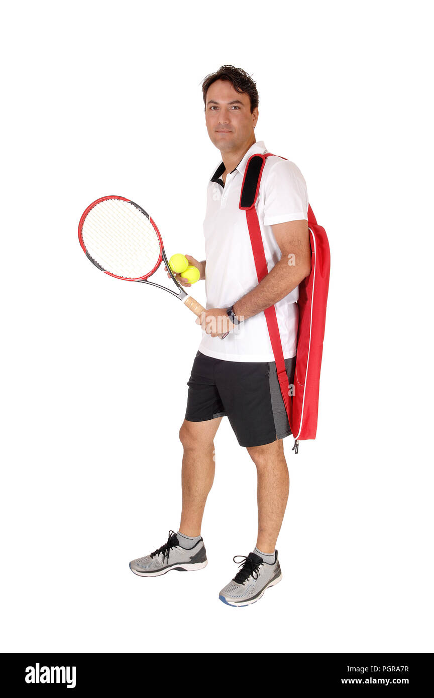 A handsome young man standing in his tennis outfit, racquet and balls ...