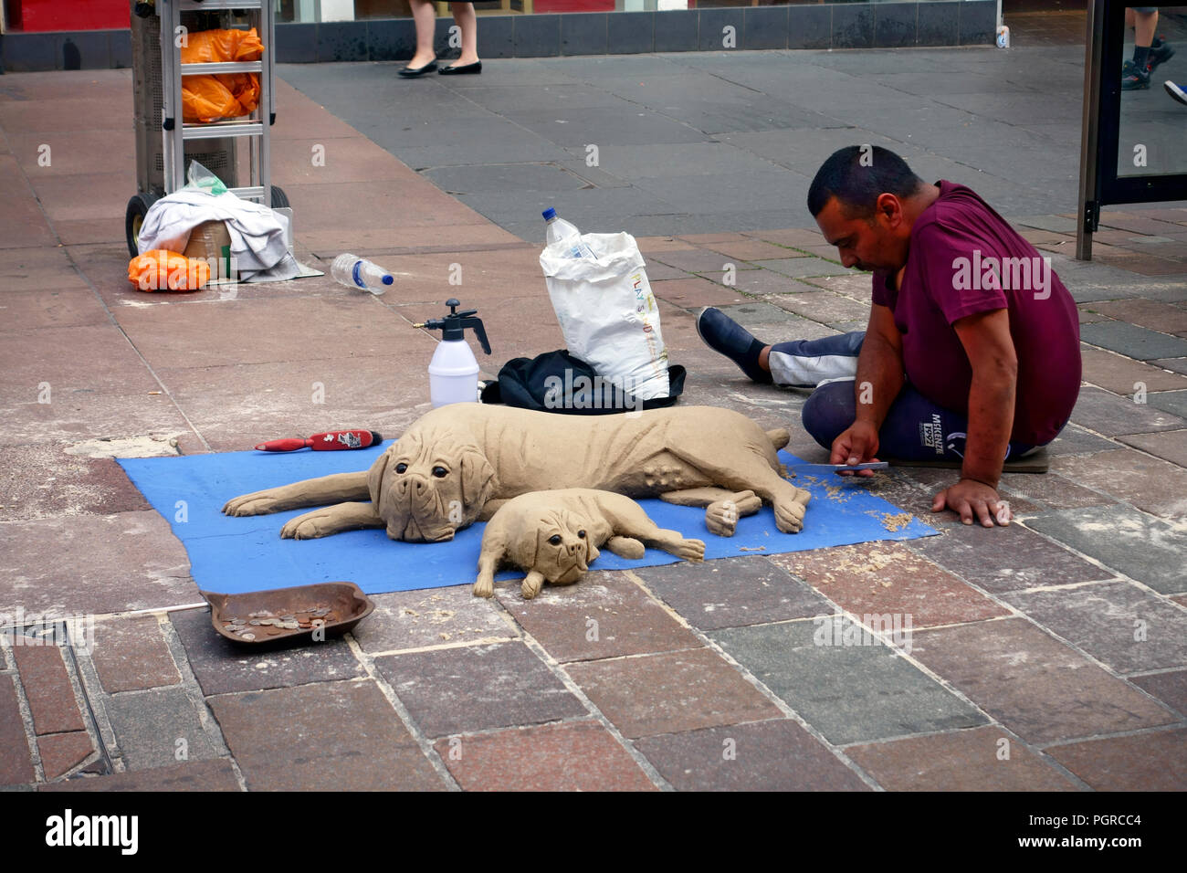 Street artist creating sand sculpture dogs on Buchanan Street, Glasgow ...