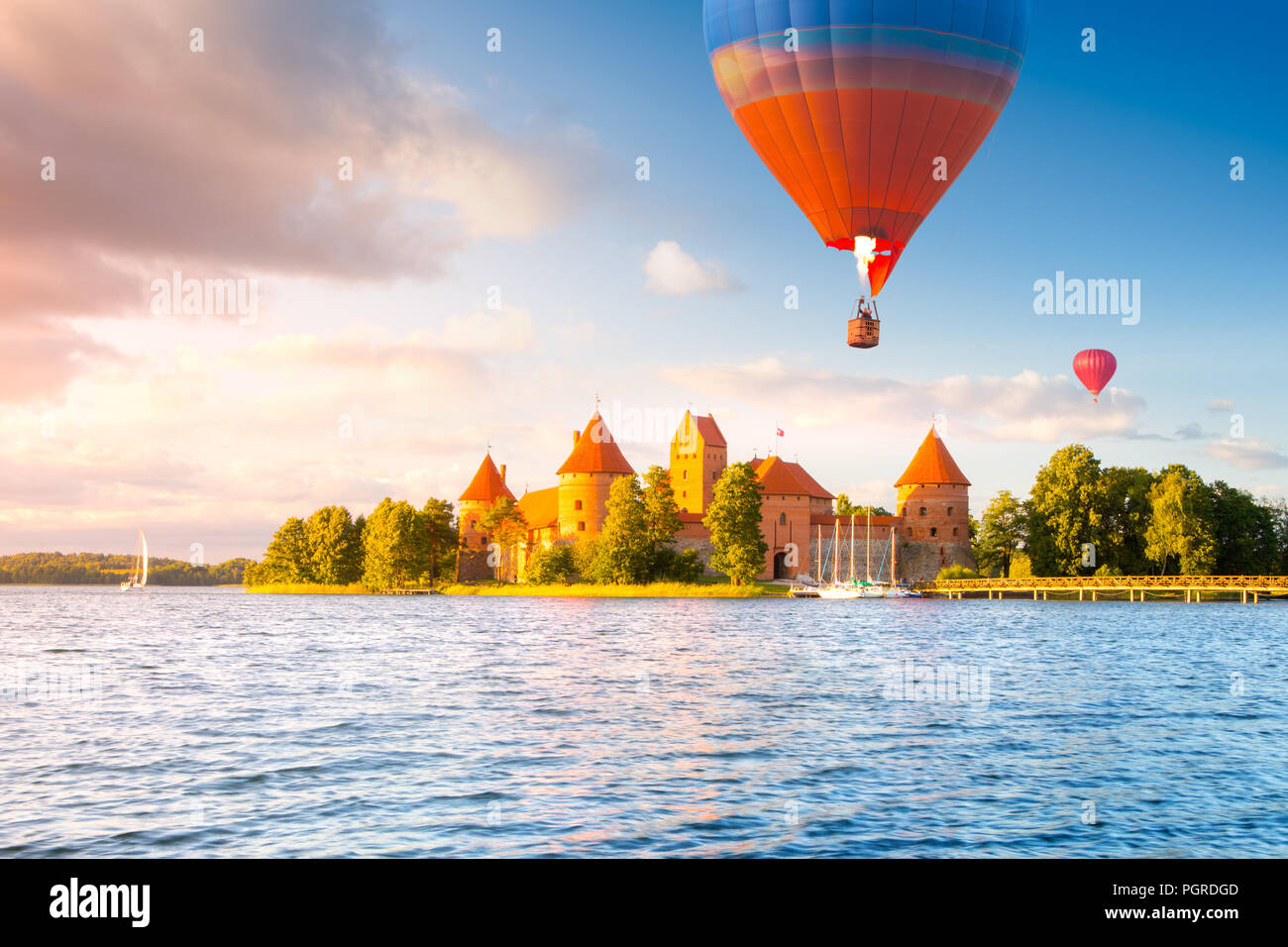 Landscape with red brick castle on island and flying air balloon in ...