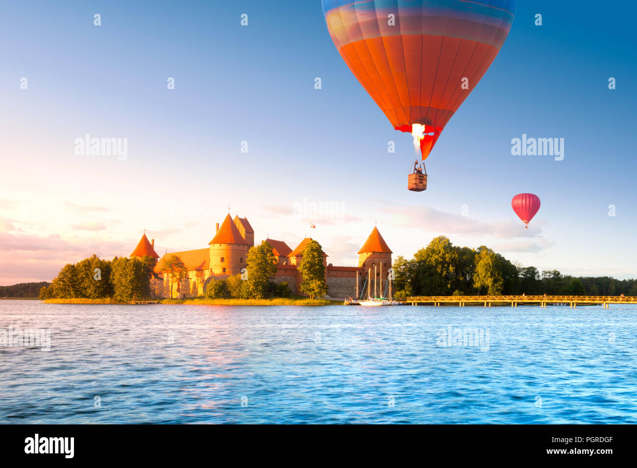 Landscape with red brick castle on island and flying air balloon in ...