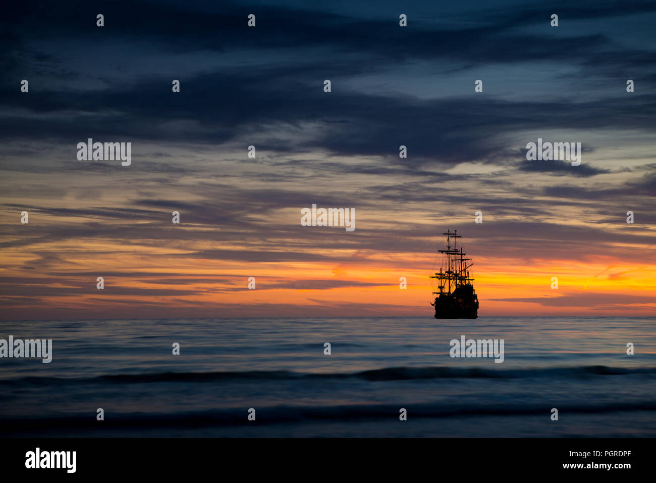 Old ship silhouette in sunset scenery Stock Photo - Alamy