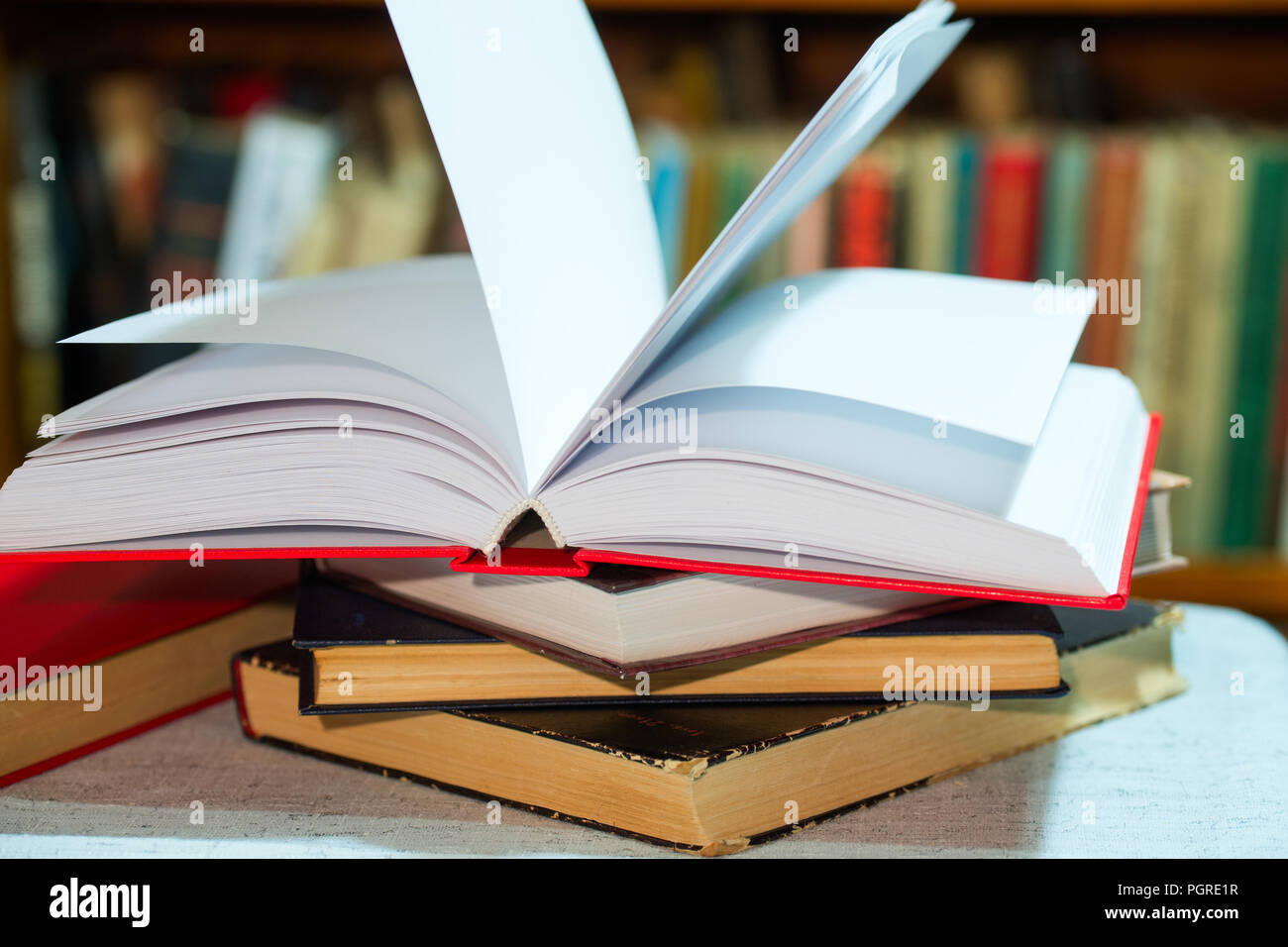 Open book, stack of hardback books on table. Top view Stock Photo - Alamy