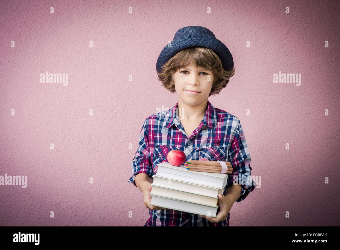 Little boy holding stack of books ready to go back to school Stock ...