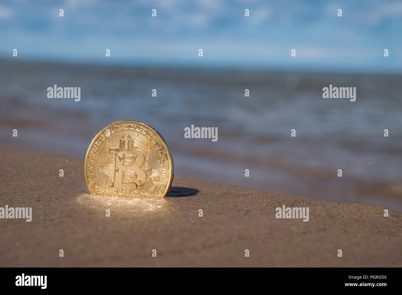 bitcoin on the beach in the sand against the sea Stock Photo - Alamy
