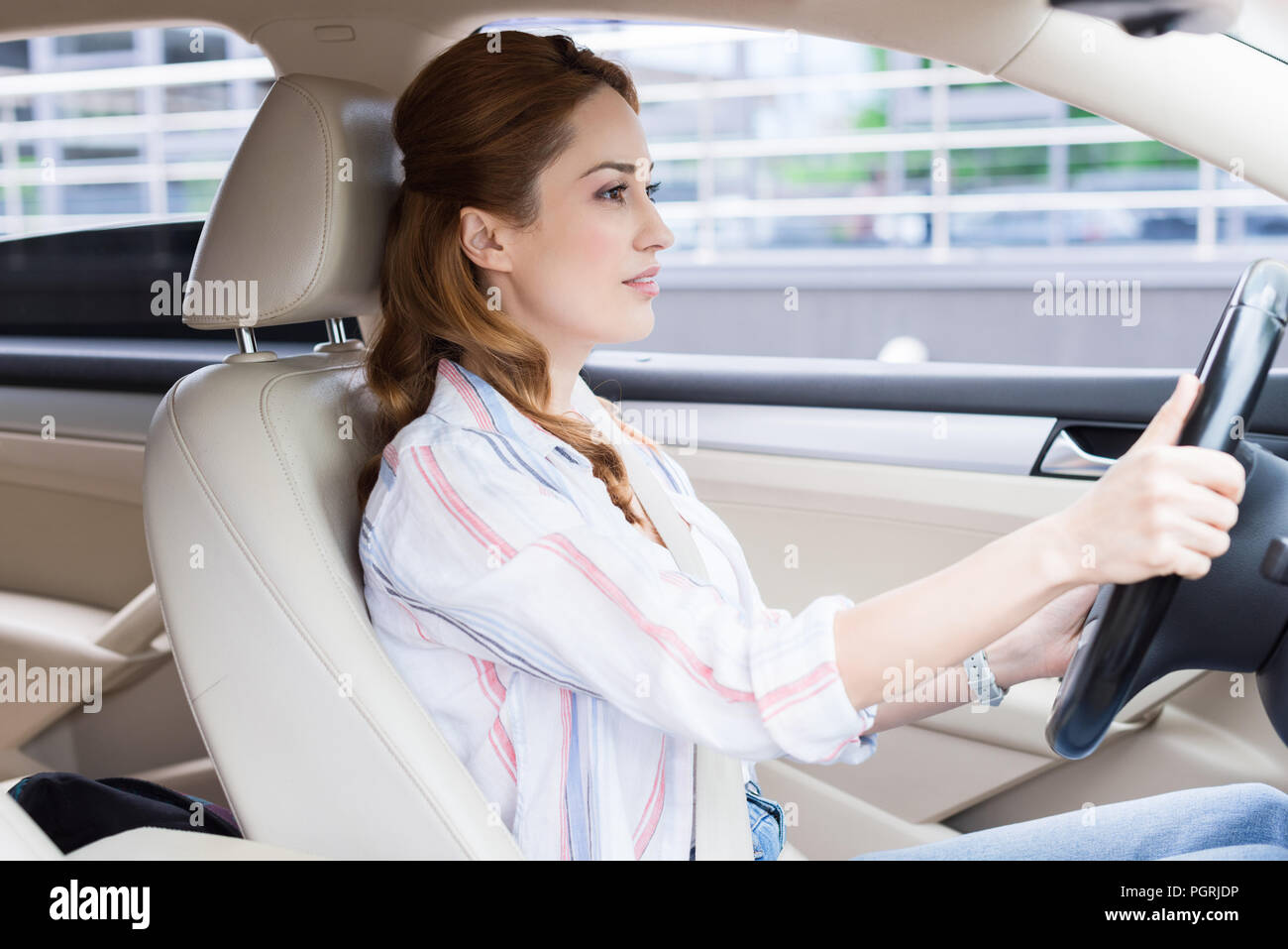 side view of attractive woman driving car alone Stock Photo - Alamy