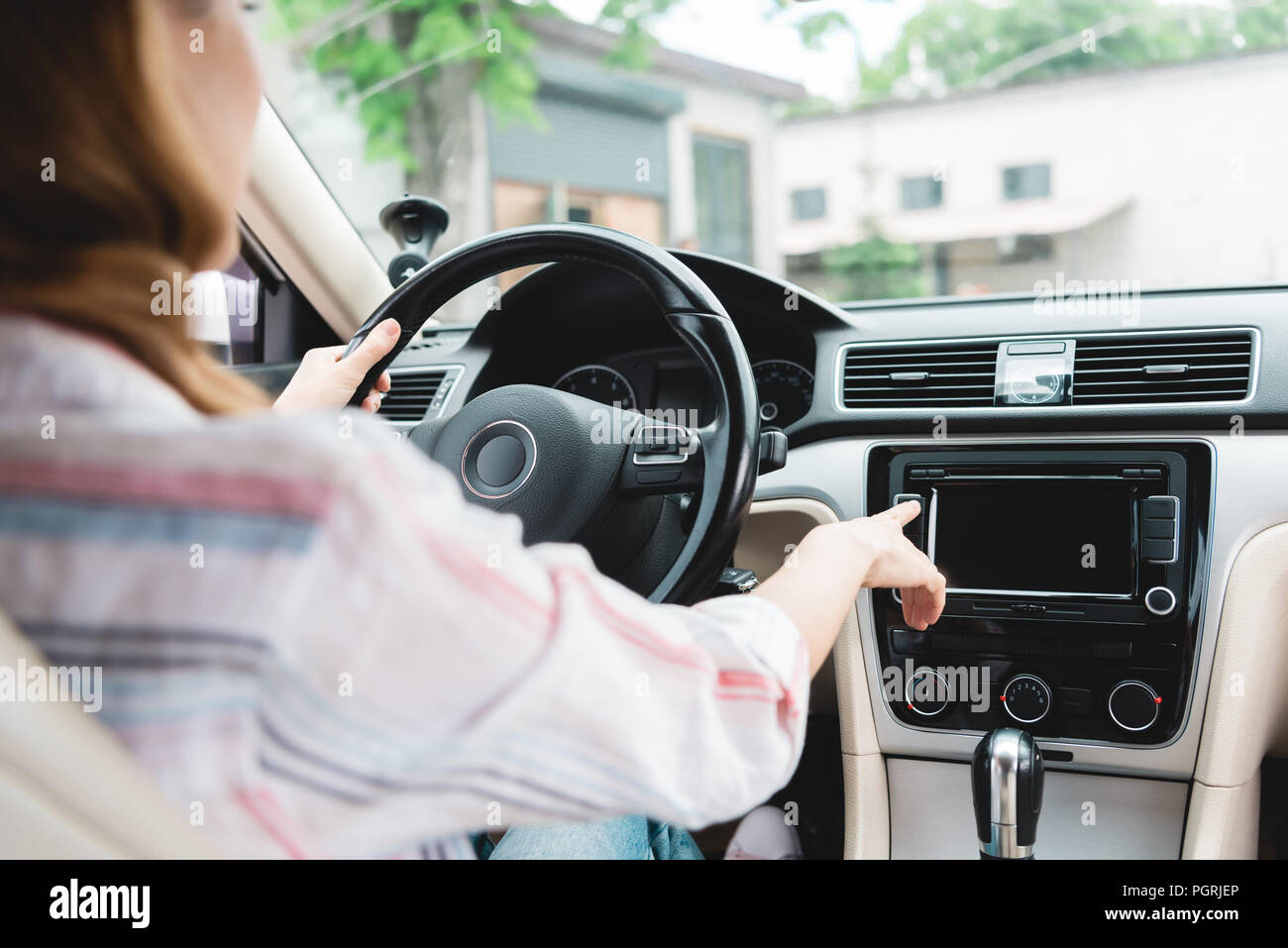 partial view of woman turning on radio while driving car Stock Photo ...
