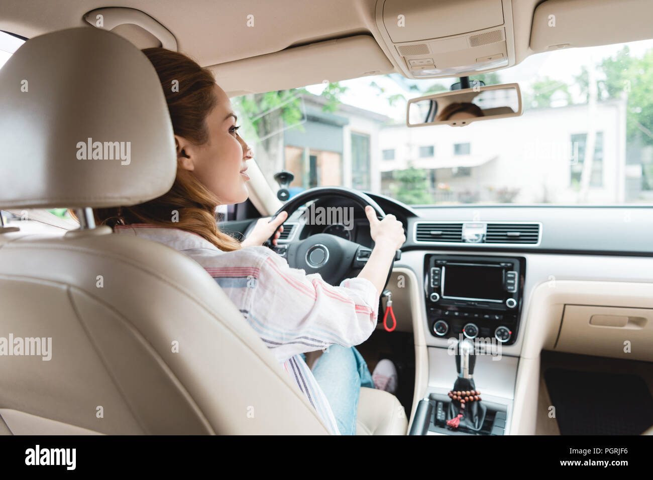 back view of woman looking away while driving car Stock Photo - Alamy
