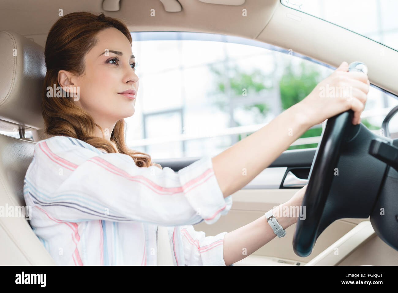 side view of attractive woman driving car alone Stock Photo - Alamy