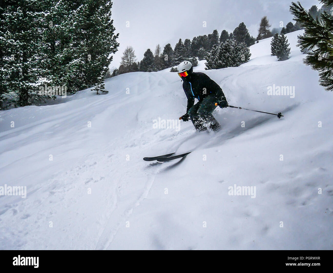 Freeride skier riding in deep snow in the Alp forest Stock Photo - Alamy