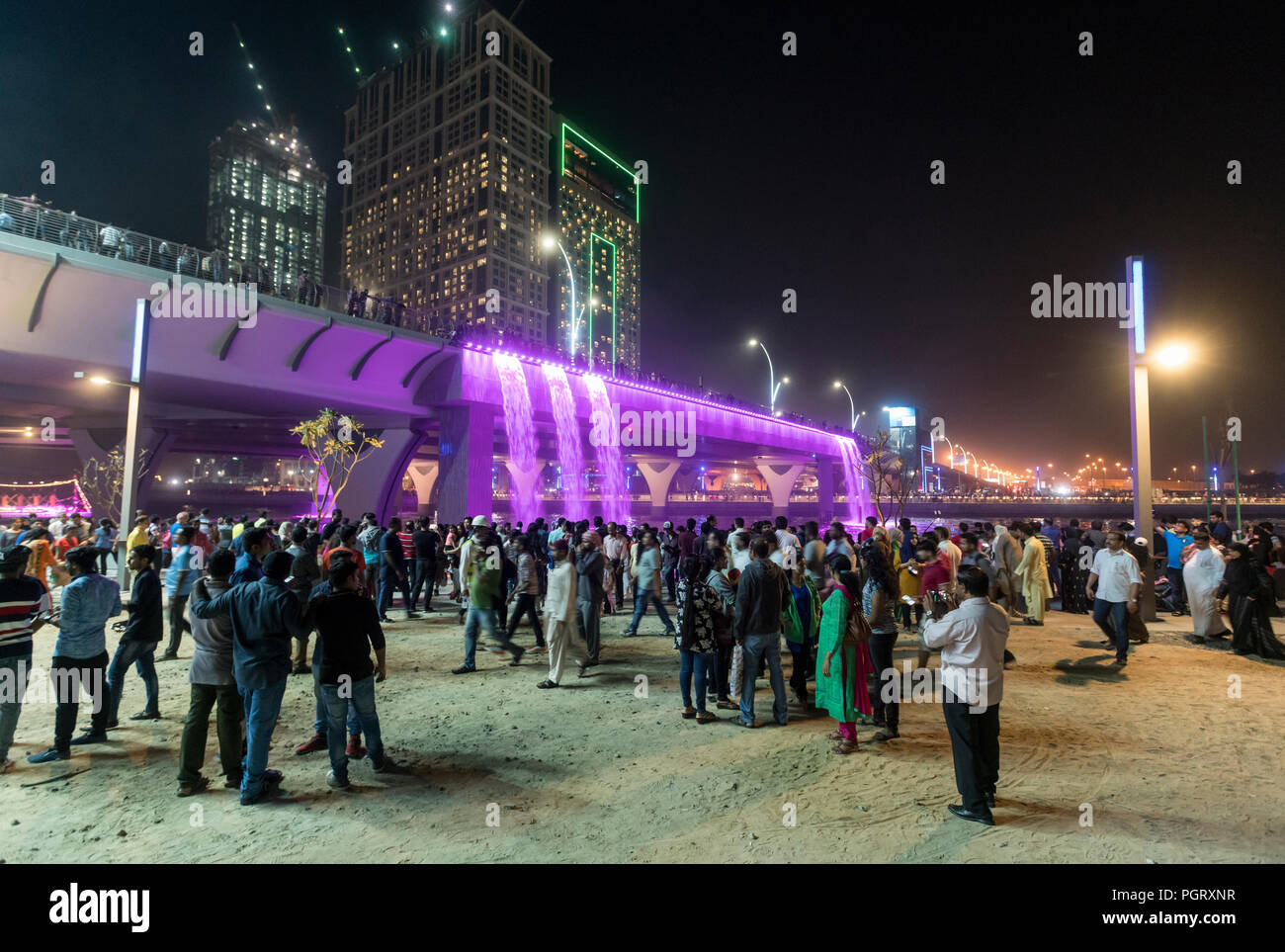 Crowds watching the neon-lit mechanical waterfall, where the Dubai ...