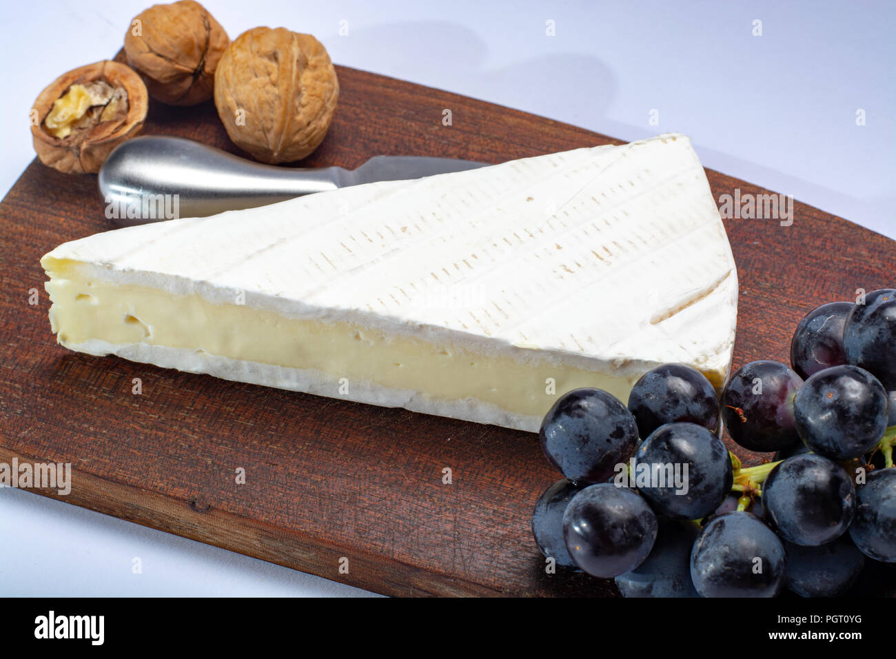 Piece of french soft-ripened white mold cow milk cheese brie produced ...