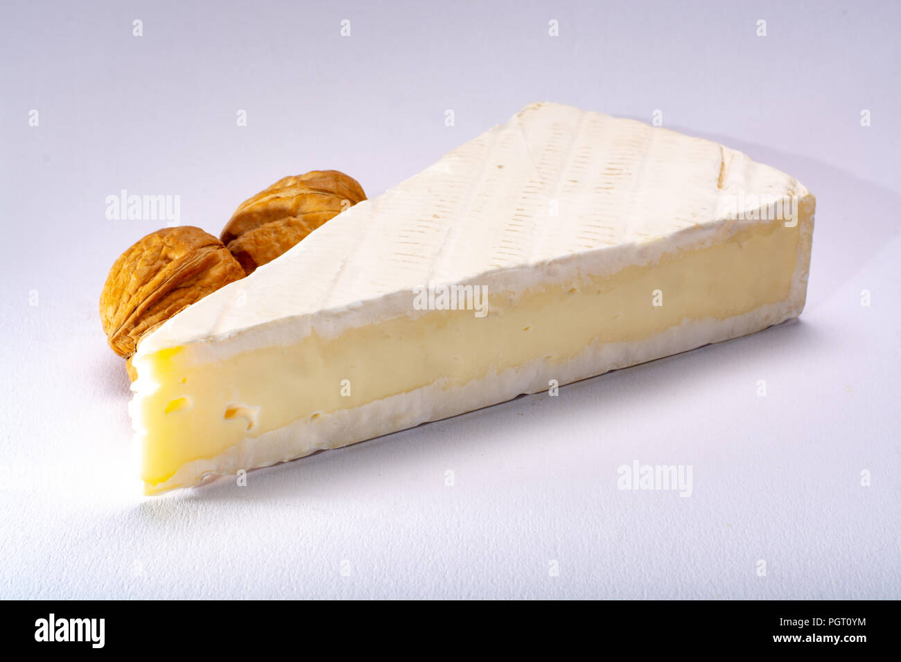 Piece of french soft-ripened white mold cow milk cheese brie produced ...